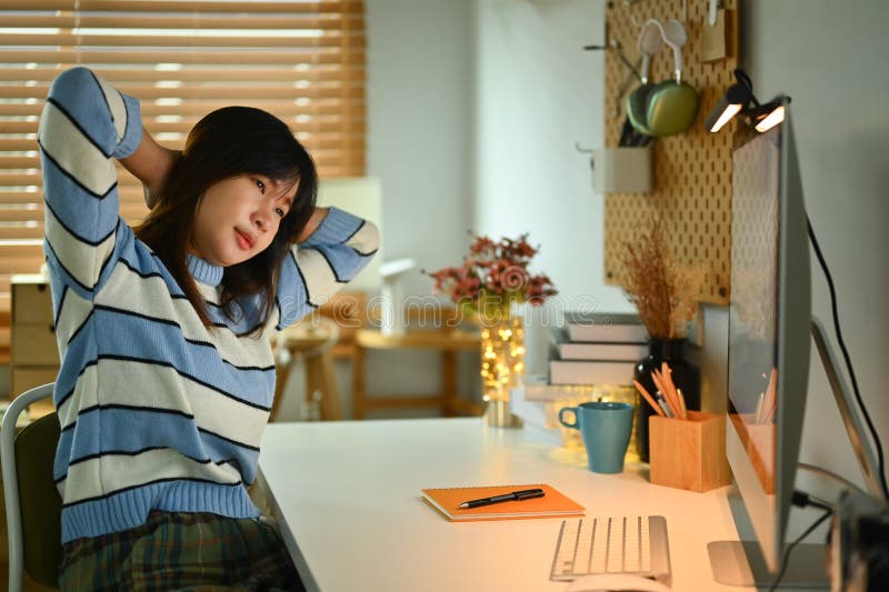 Young Woman Relaxing at Workplace with Hands Behind Head, Satisfied ...