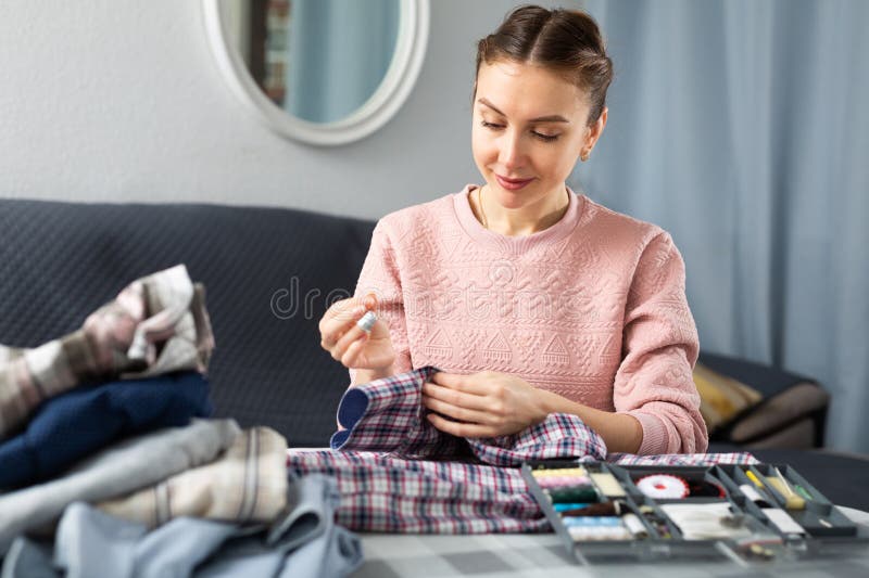Woman Repairing Clothes with a Needle and Thread Stock Photo - Image of ...