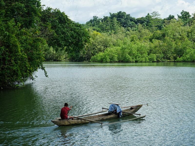 A Young Woman is Rowing a Canoe at the Mouth of a River. Editorial ...