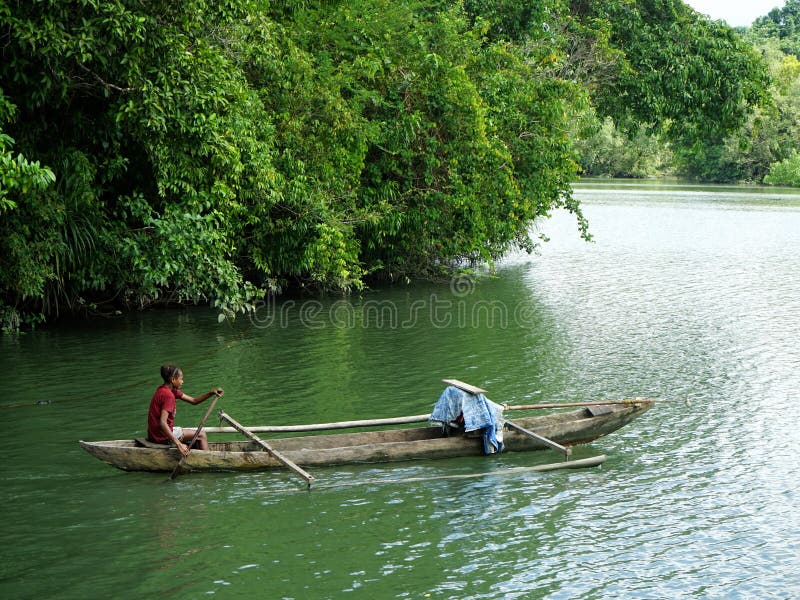 A Young Woman is Rowing a Canoe Towards the Middle of the River Estuary ...