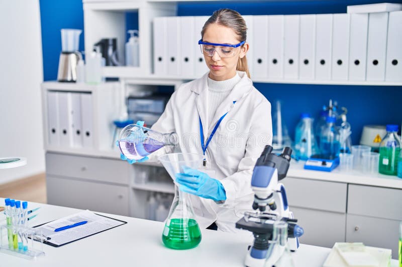 Young Woman Scientist Measuring Liquid at Laboratory Stock Photo ...