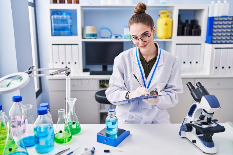 Young Woman Scientist Measuring Liquid Writing on Document at ...