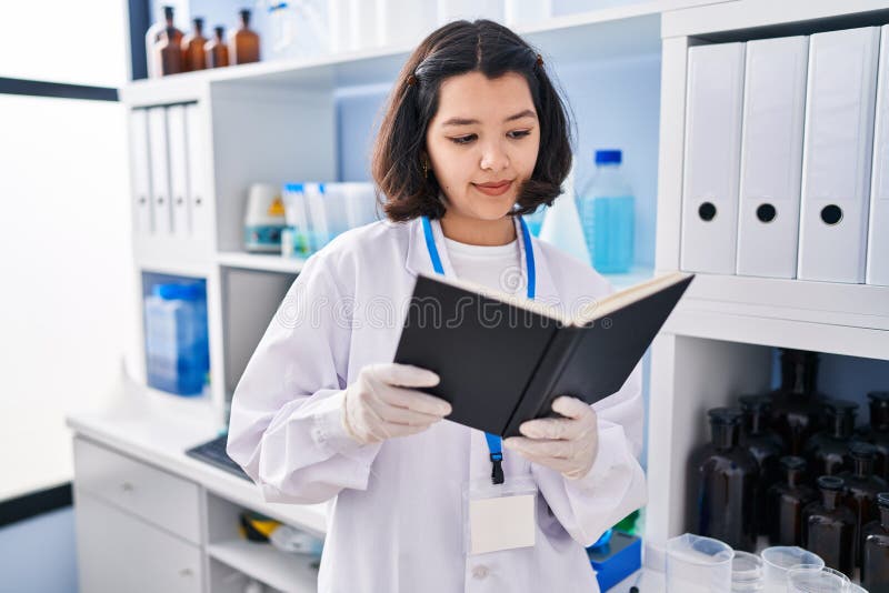 Young Woman Scientist Reading Book at Laboratory Stock Photo - Image of ...