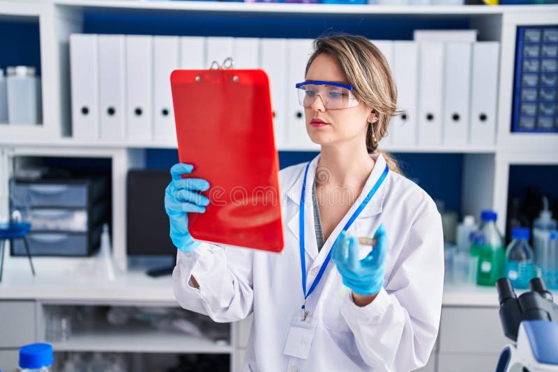 Young Woman Scientist Reading Report Holding Sample at Laboratory Stock ...
