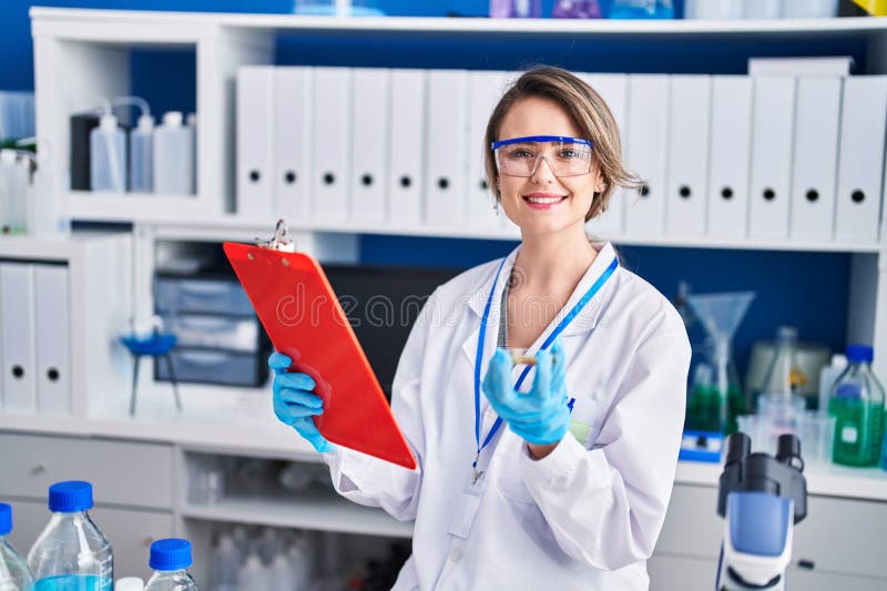 Young Woman Scientist Reading Report Holding Sample at Laboratory Stock ...
