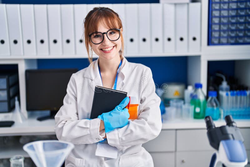 Young Woman Scientist Smiling Confident Hugging Book at Laboratory ...