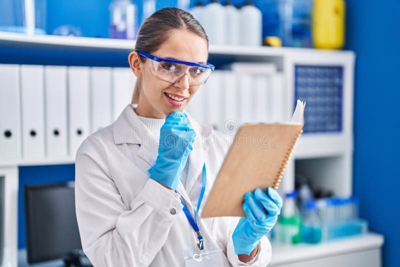 Young Woman Scientist Smiling Confident Reading Book at Laboratory ...