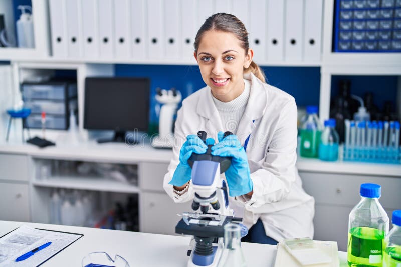 Young Woman Scientist Smiling Confident Using Microscope at Laboratory ...