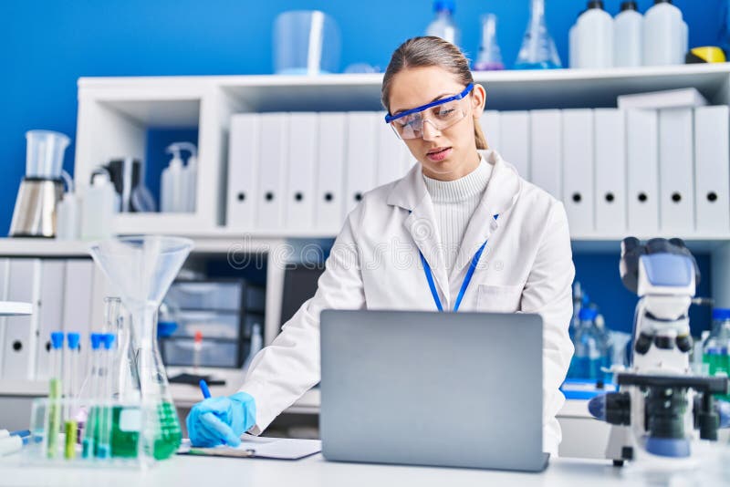 Young Woman Scientist Writing on Clipboard at Laboratory Stock Photo ...