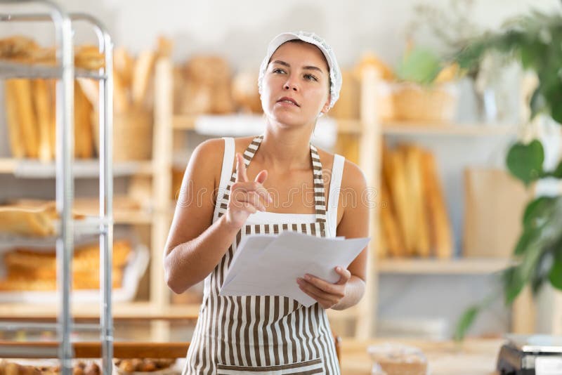Young Woman Seller Reading Document in Bakery Stock Image - Image of ...
