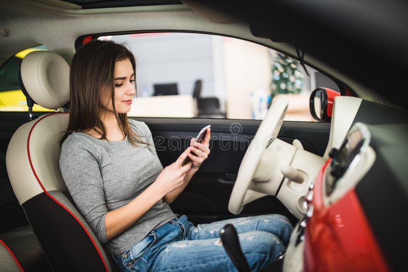 Young Woman Sending Messages while Driving in a New Car Stock Image ...