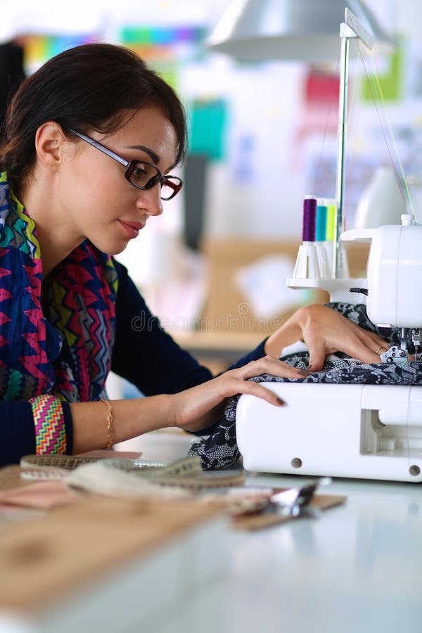 Young Woman Sewing while Sitting at Her Working Place Stock Photo ...