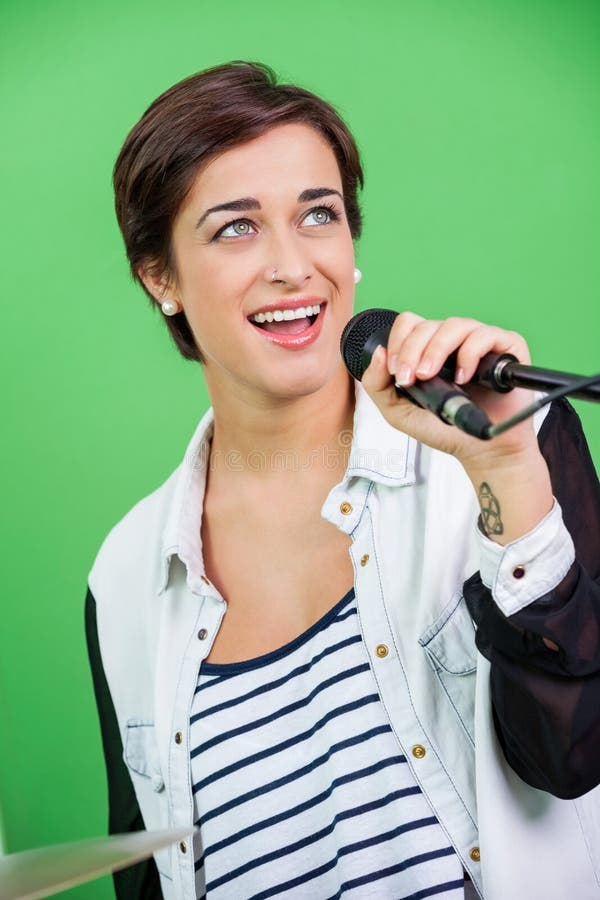 Young Woman Singing while Holding Microphone Stock Photo - Image of ... Young Woman Singing while Holding Microphone Stock Photo - Image of ...