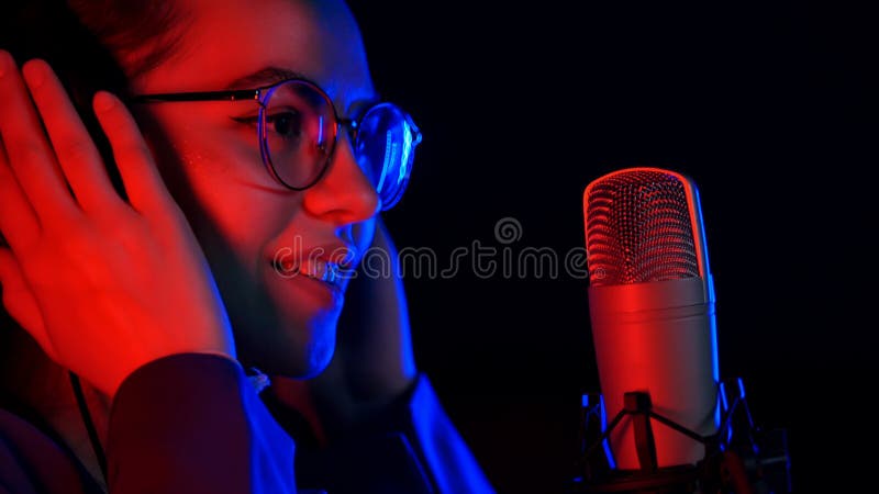 A Young Woman Singing in Neon Lighting in the Studio Stock Photo ...