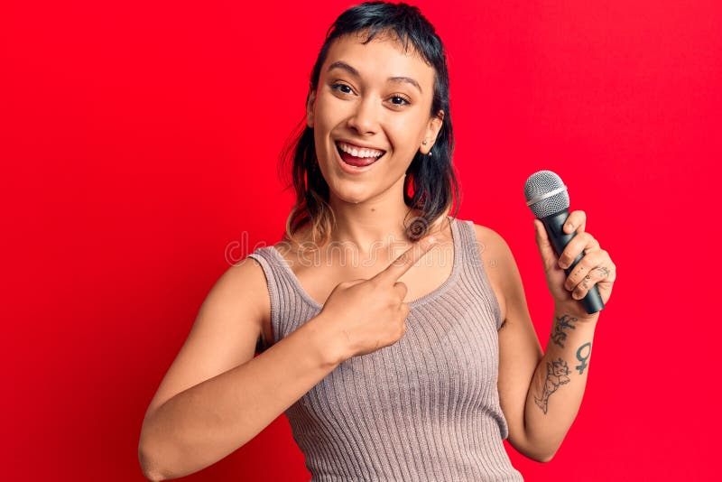 Young Woman Singing Song Using Microphone Smiling Happy Pointing with ...