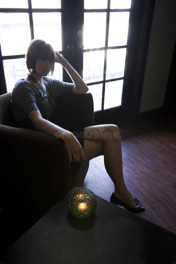 Young Woman Sitting Alone in Dark Room Thinking Stock Image - Image of ...