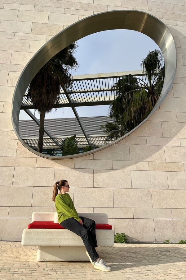 Young Woman Sitting on the Bench in Front of a Modern Building Stock ...
