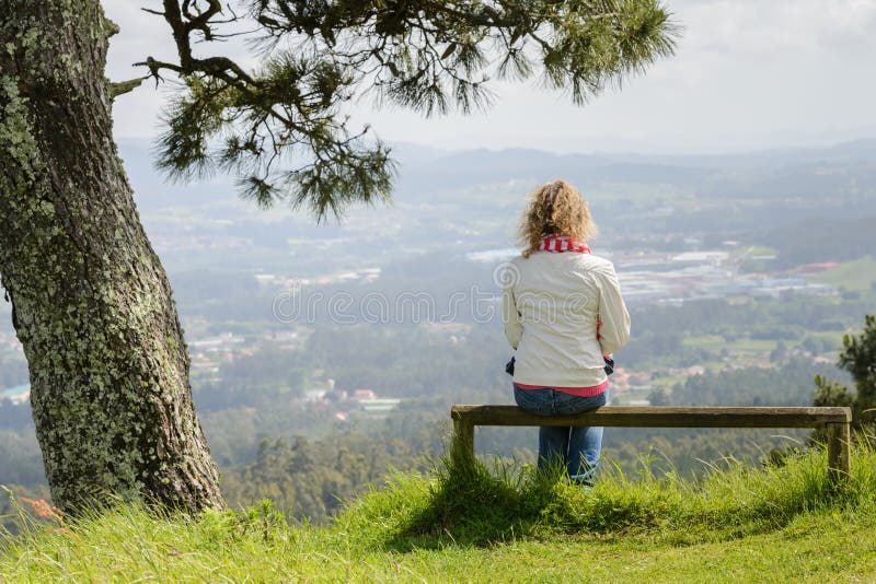 Young Woman Sitting on a Bench Looking at the Nature Stock Photo ...