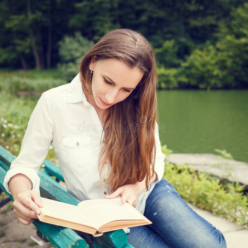 Young Woman Sitting On The Bench And Reading Book Stock Image Image