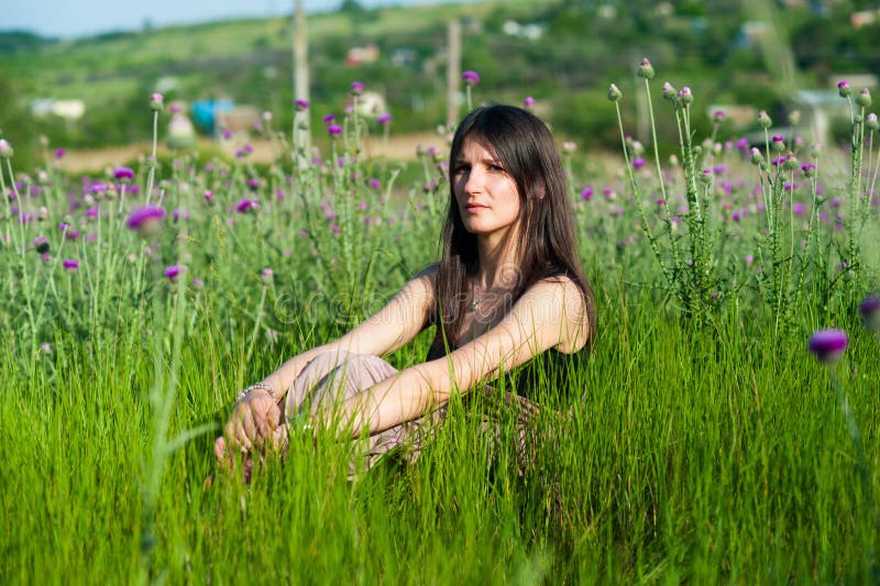 Young Woman Sitting in Grass Stock Photo - Image of field, brunette ...