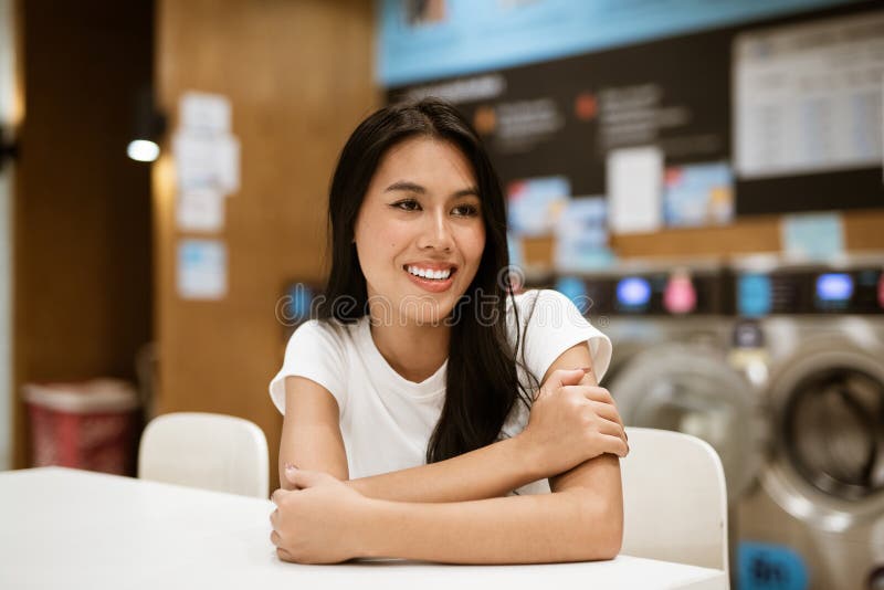 Young Woman Sitting in Laundry Shop Stock Image - Image of cheerful ...