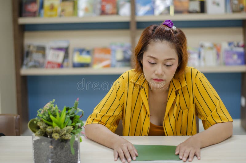 Young Woman Sitting in the Library Reading a Book Stock Image - Image ...
