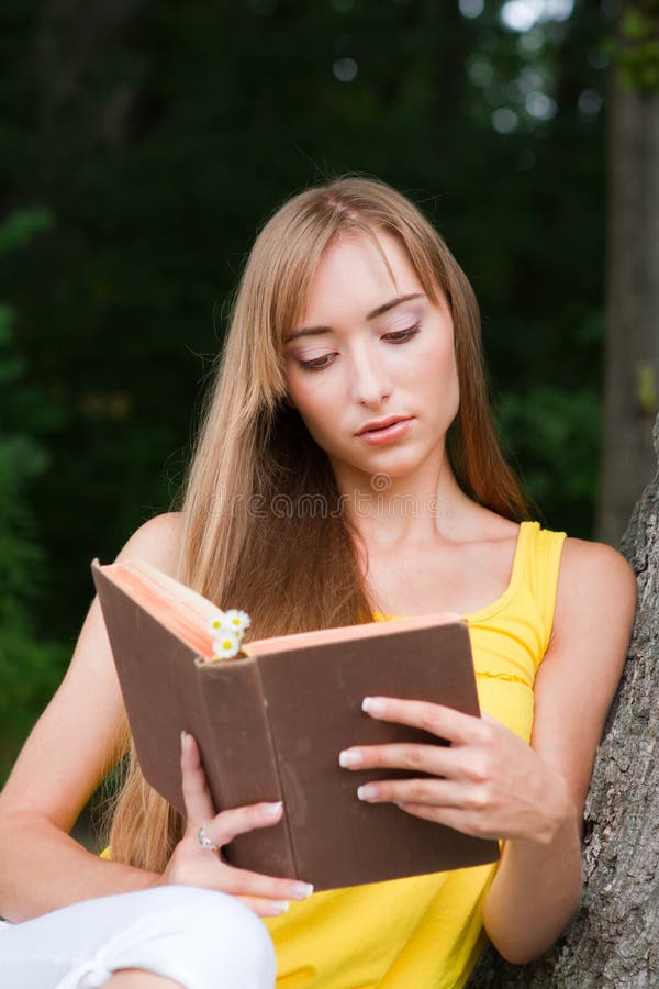 Young Woman Sitting Near a Tree,reading a Book Stock Image - Image of ...