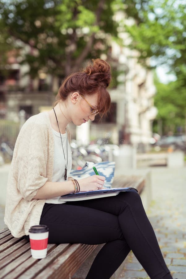 Young Woman Sitting on a Park Bench Working Stock Photo - Image of ...