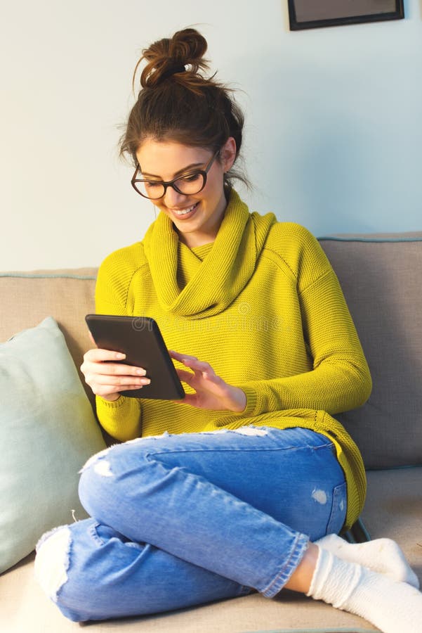 Young Woman Sitting in a Room, Using a Tablet Stock Photo - Image of ...