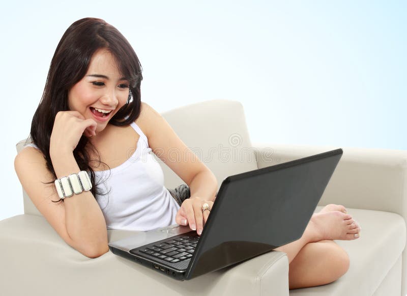 Young Woman Sitting in Sofa Using a Laptop Stock Image - Image of ...