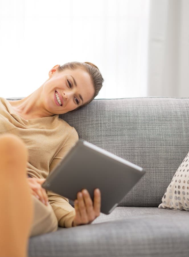 Young Woman Sitting on Sofa and Using Tablet Pc Stock Photo - Image of ...