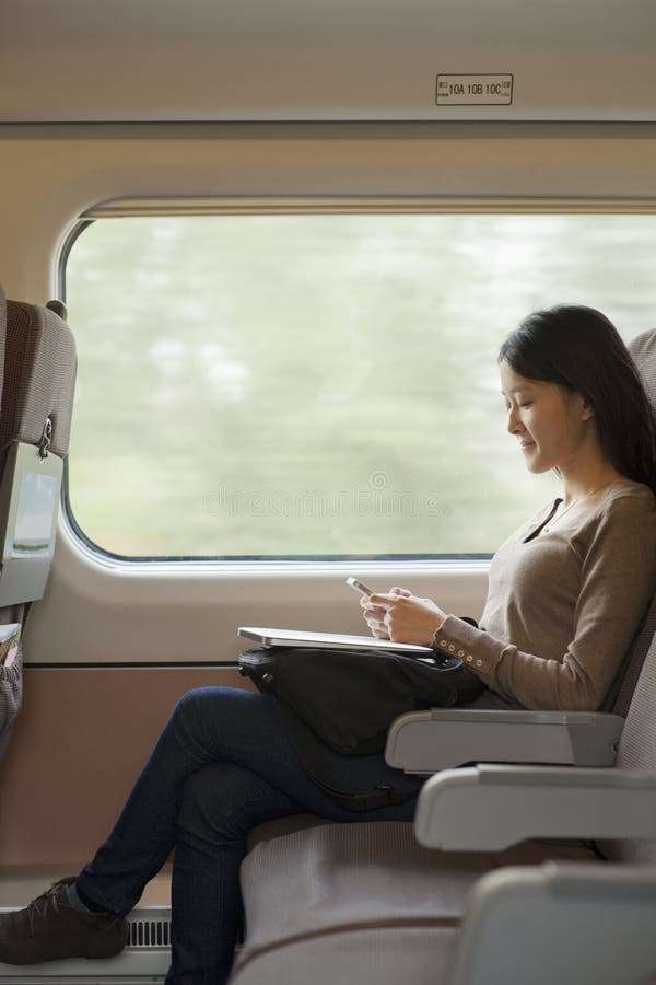 Young Woman Sitting on a Train Using Her Phone Stock Photo - Image of ...