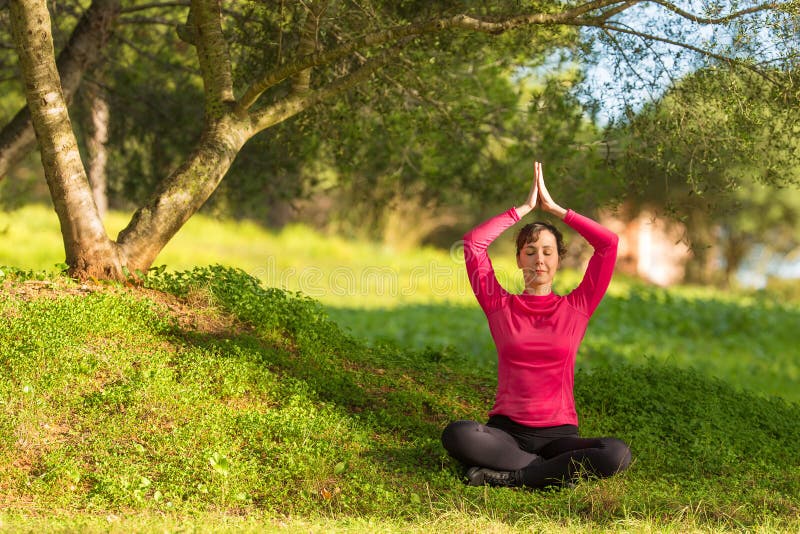 Young Woman Sitting Under a Tree and Meditating Stock Photo - Image of ...
