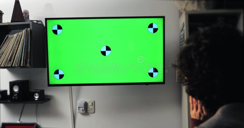 Woman Watching TV Displaying a Green Screen with Tracking Points Stock ...