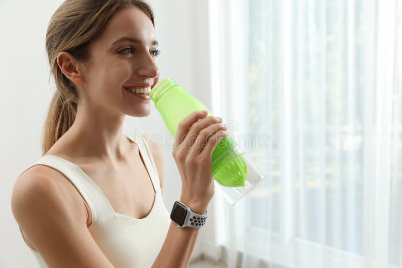 Young Woman with Smart Watch Drinking Water Indoors, Space for Text ...