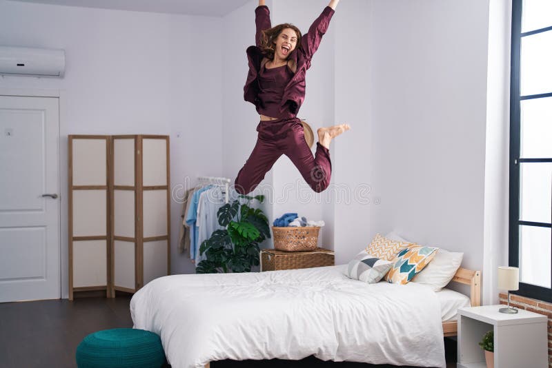 Young Woman Smiling Confident Jumping on Bed at Bedroom Stock Image ...