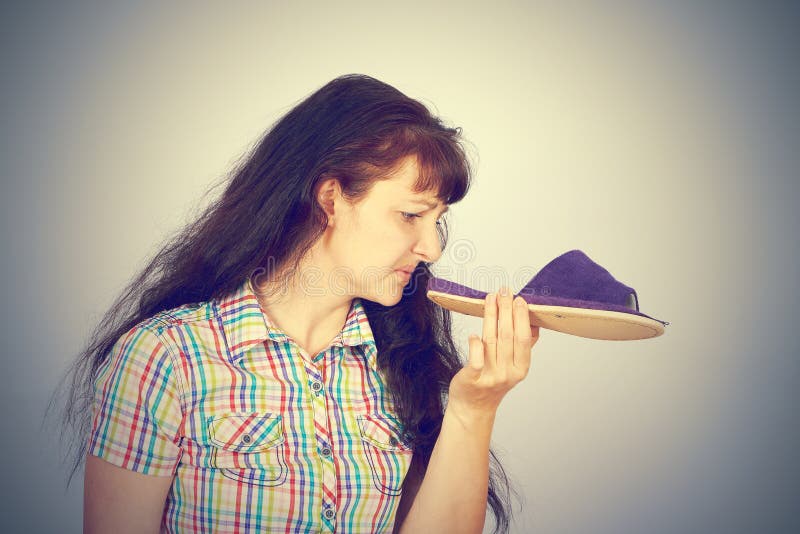 Young Woman Sniffs Smelly Slippers. Stock Image - Image of background ...