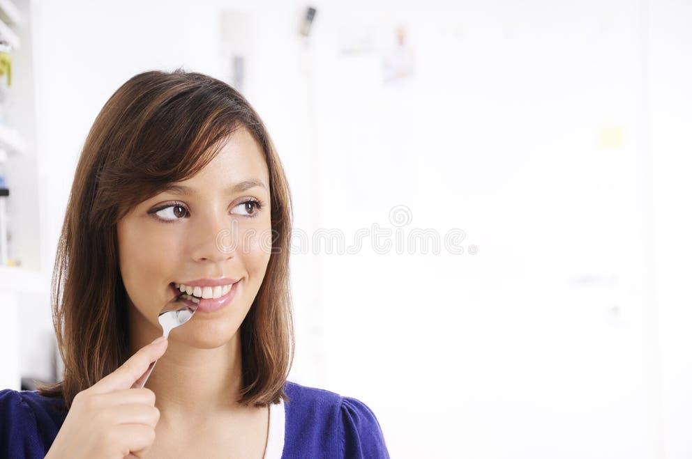 Young Woman with Spoon on Lips Stock Photo - Image of smiling, looking ...