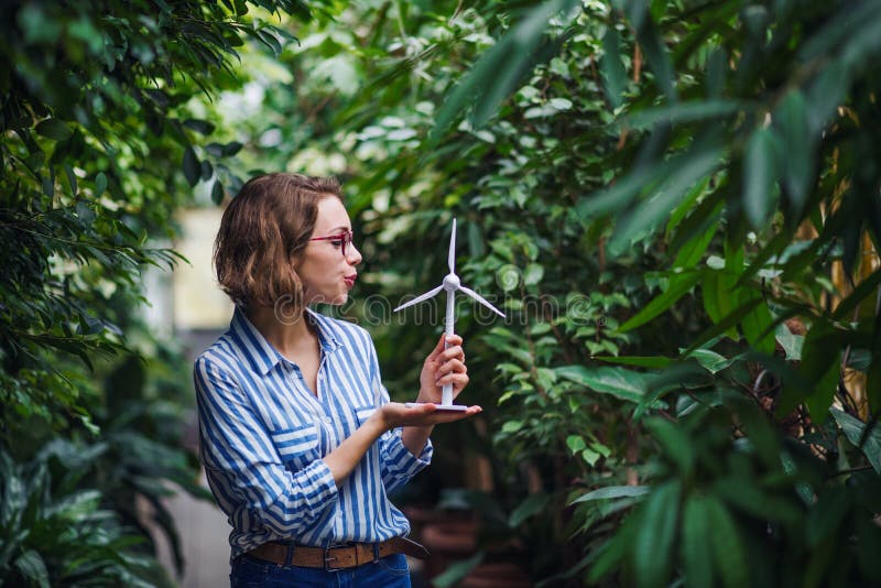 Young Woman Standing in Botanical Garden, Holding Windmill Model. Stock ...