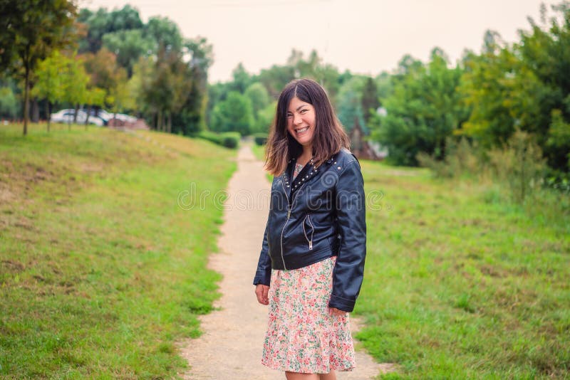 Smiling Young Woman Standing on the Path in the Park Stock Photo ...