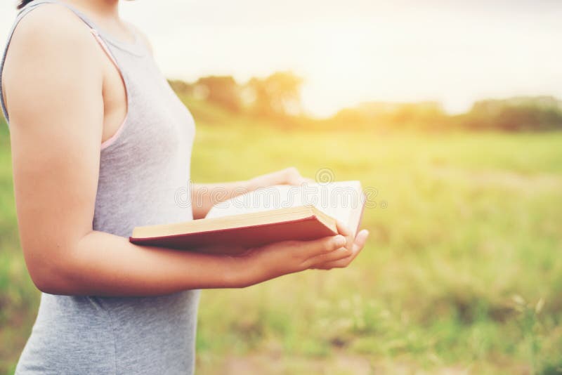 Young Woman Standing Reading Book at Meadows. Stock Image - Image of ...
