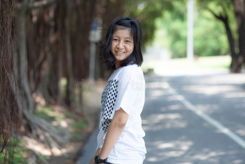 Young Woman Standing Under a Large Tree. Stock Image - Image of ...