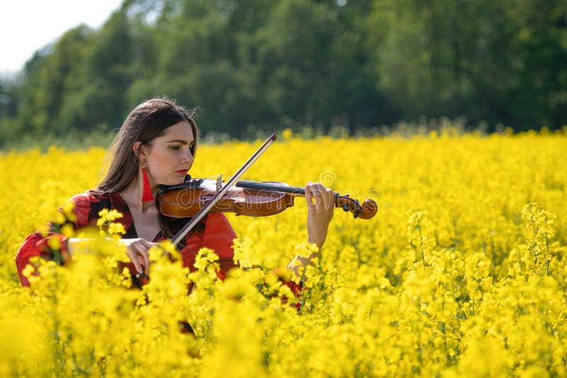 Young Woman Standing in Yellow 0oilseed Field and Playing Violin ...