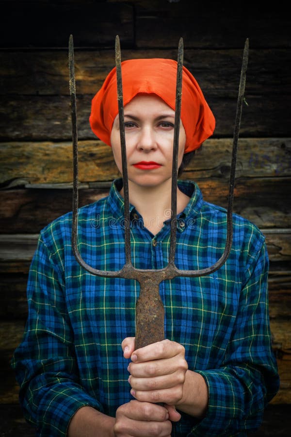 Young Woman Stands with a Pitchfork Near a Stable on a Ranch Stock ...