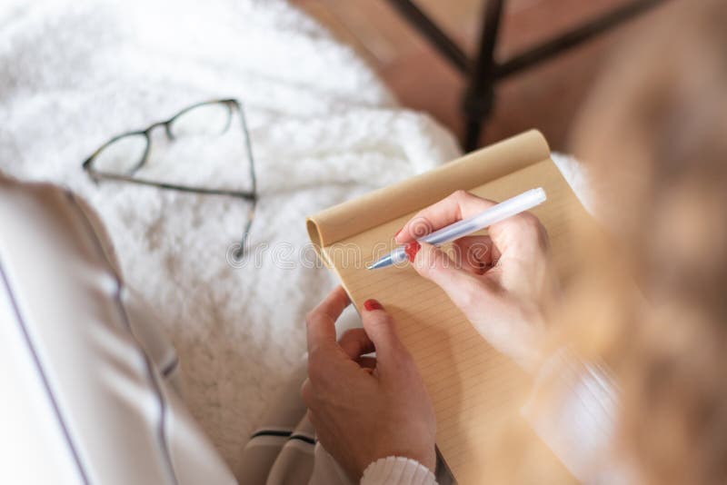 Young Woman Starting To Write in a Notebook on the Sofa at Home. Stock ...