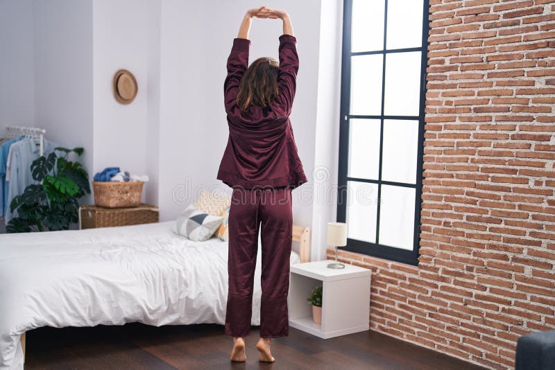 Young Woman Stretching Arms Standing on Back View at Bedroom Stock ...