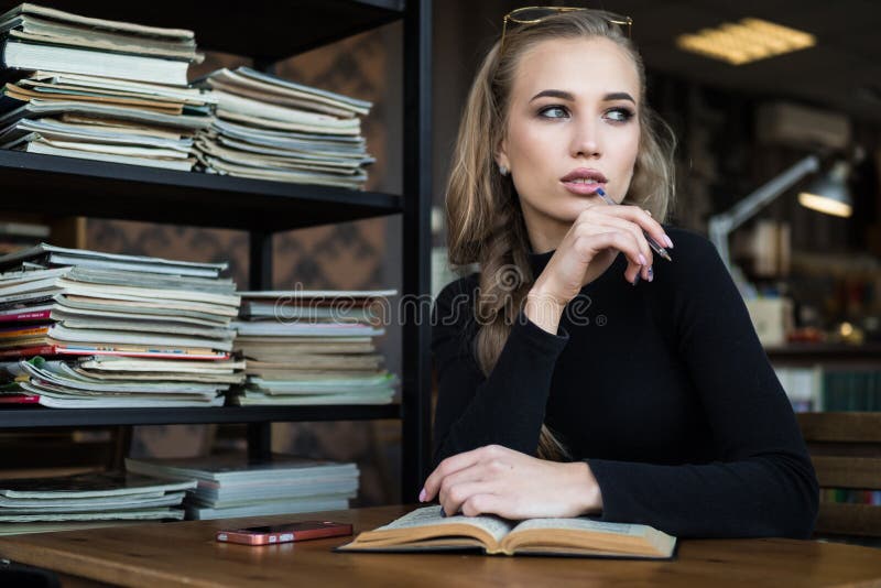 Young Woman Student, Bored To Read Book in a Library Stock Photo ...