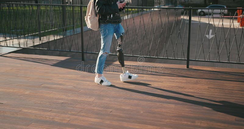 Young Woman Student with Prosthetic Leg Walking in University Campus ...