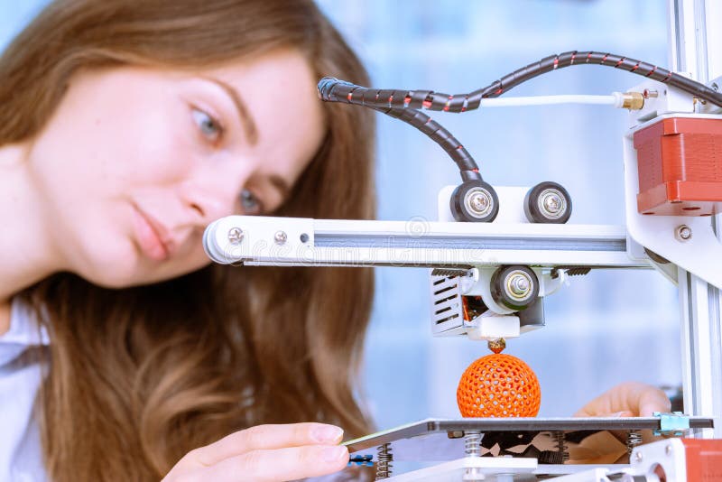 Young Woman Student Working on a 3d Printer while Sitting at the Table ...