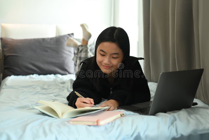 Young Woman during Study Online on Laptop and Making Notes on Notepad ...